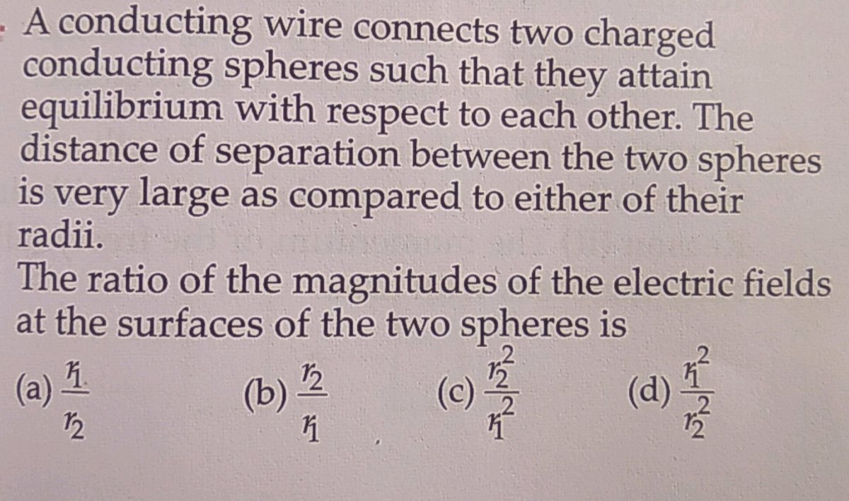 A conducting wire connects two charged conducting spheres such that they