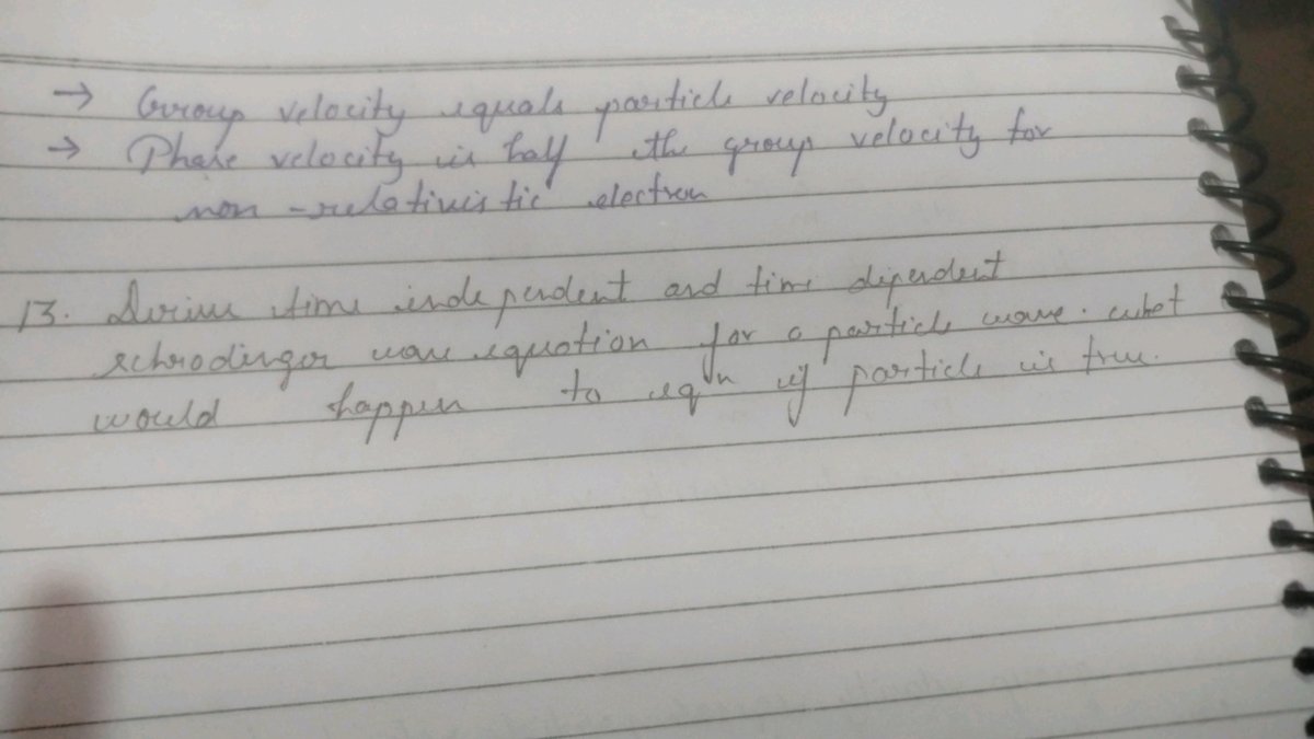 Group velocity equals particle velocity. Phase velocity is half the group..