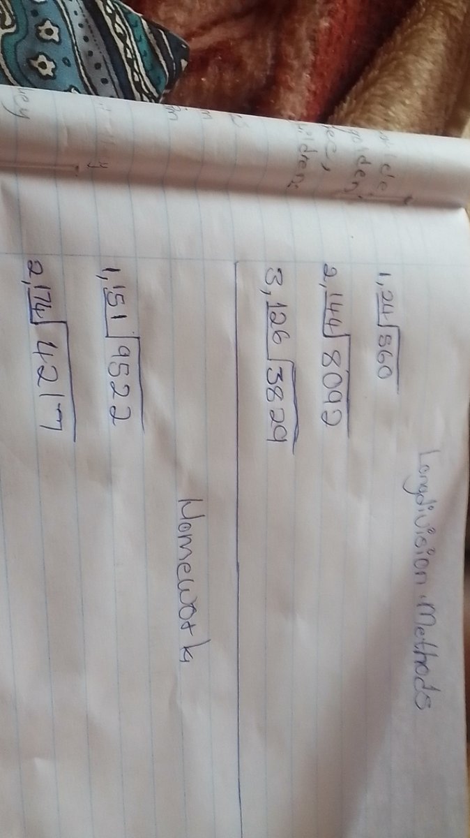 The image shows several long division problems written out. The student i..